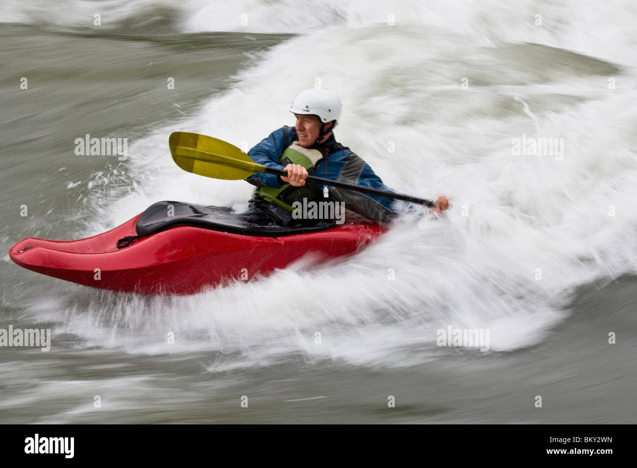 A young man surfing a wave in a whitewater kayak, Elk river, East ...