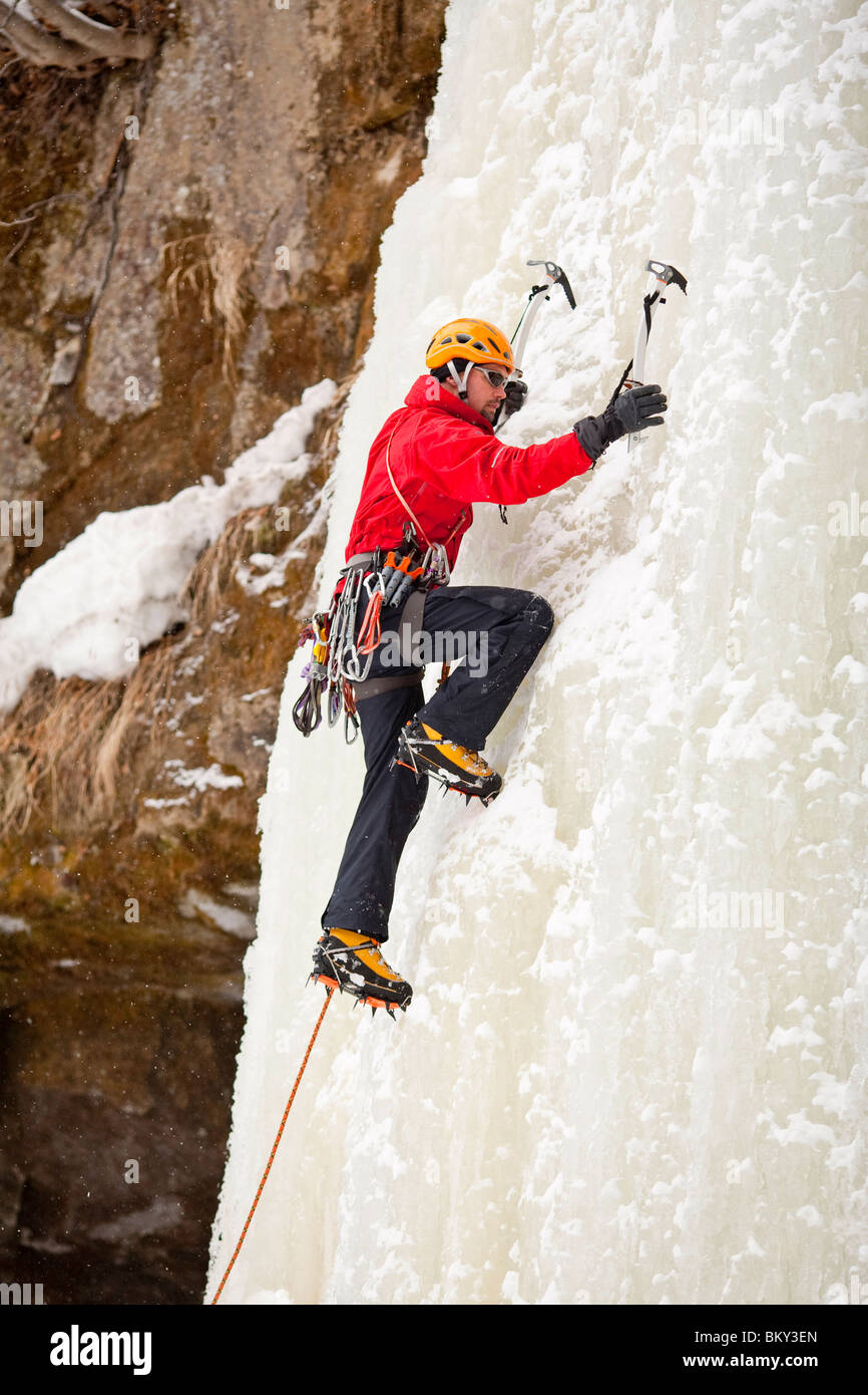 A man is climbing a frozen waterfall in Sounkyo Gorge, Daisetsuzan ...