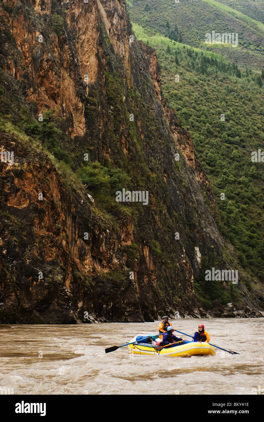 A rubber raft rows downstream during a whitewater rafting trip to ...