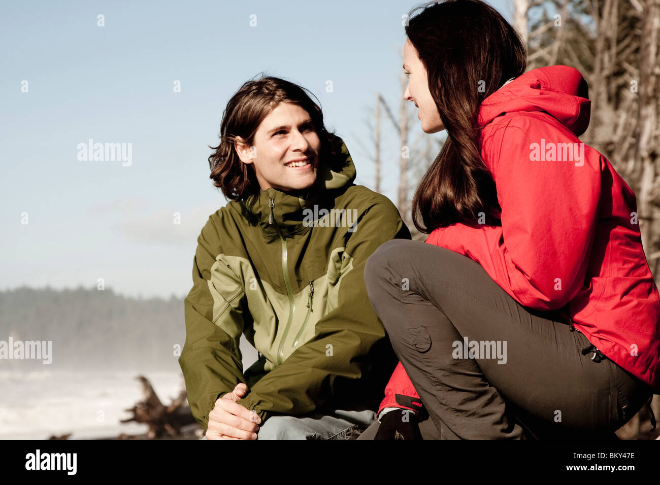 A couple sitting on a large drift log at Rialto Beach Stock Photo - Alamy