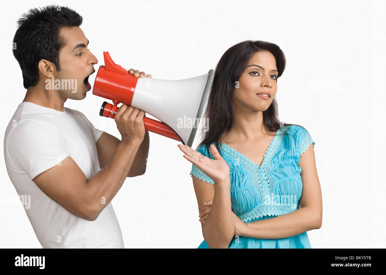 Man shouting into a megaphone at a woman Stock Photo - Alamy