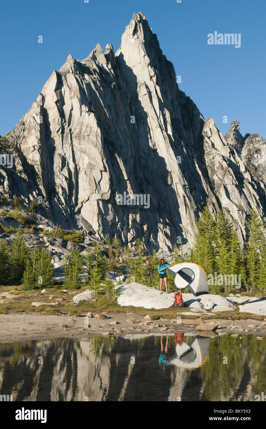 A Woman Camping On A Pristine Alpine Lake Below A Peak Enchantment