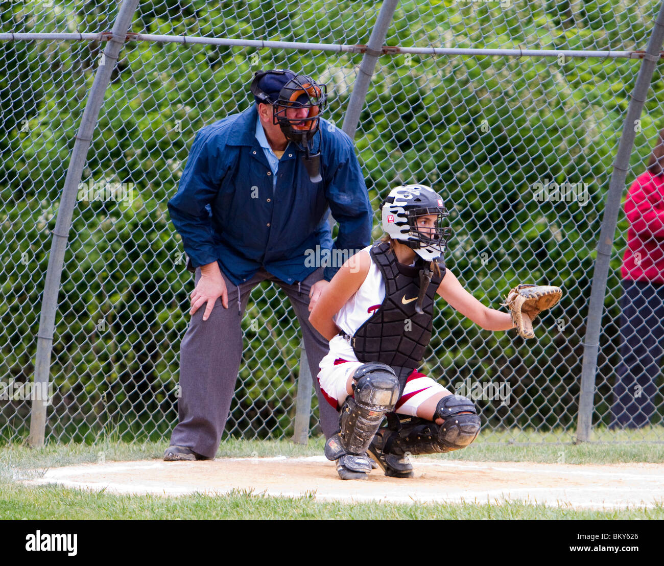 Action at a girls high school soft ball game. Catcher and batter at ...