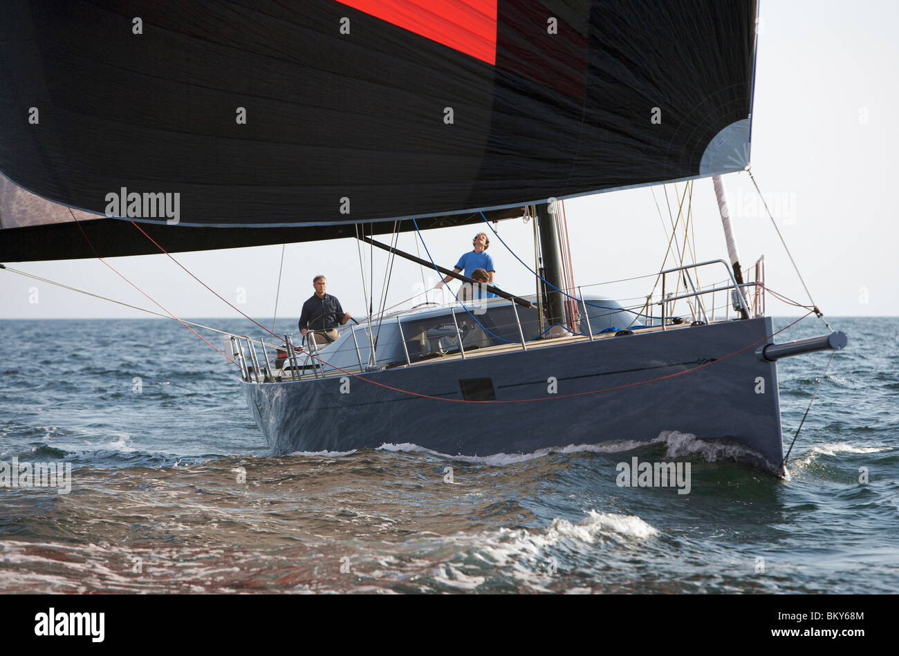 A crew races a modern ocean-going sailing yacht under spinnaker Stock ...