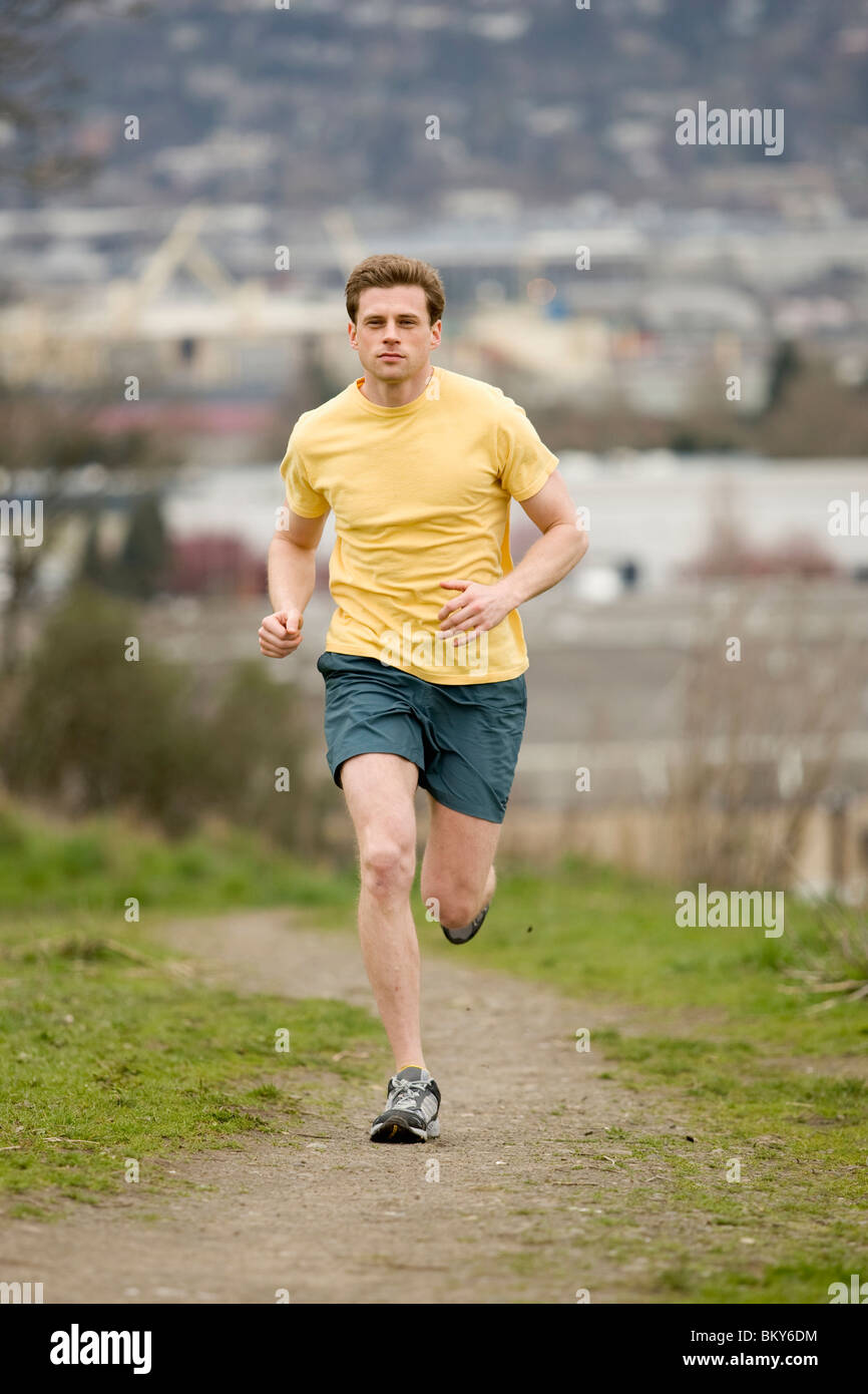An athletic man jogging along a trail with Portland, Oregon in the ...