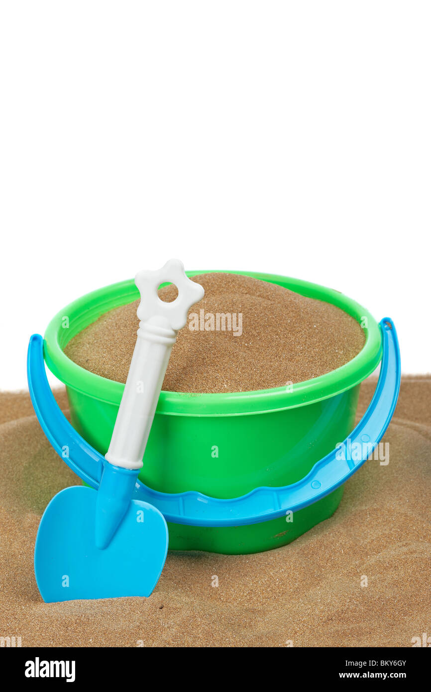 Bucket full and shovel on the sand with copy space on a white ...