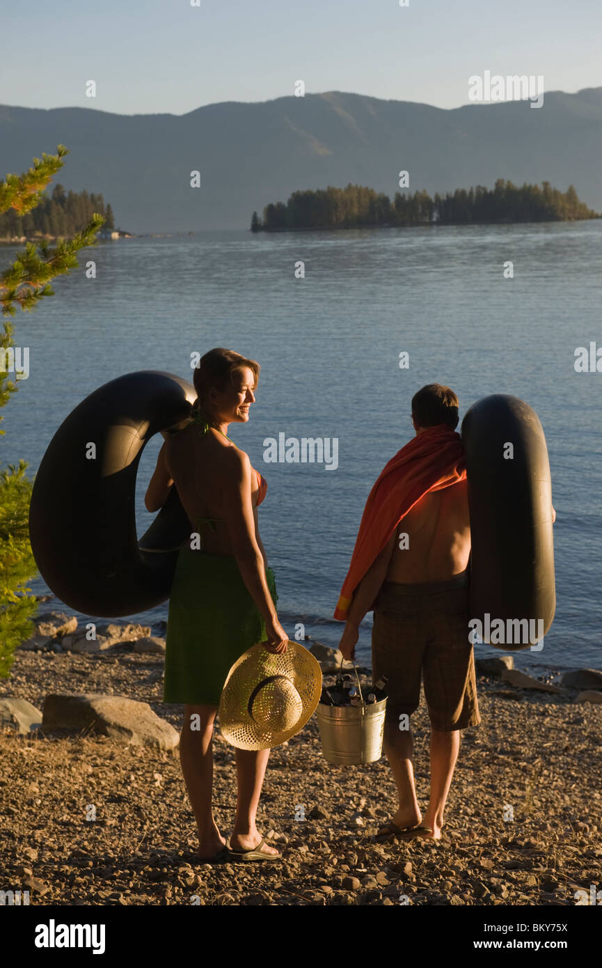 A young couple prepare to float on the lake in inner tubes during a hot ...