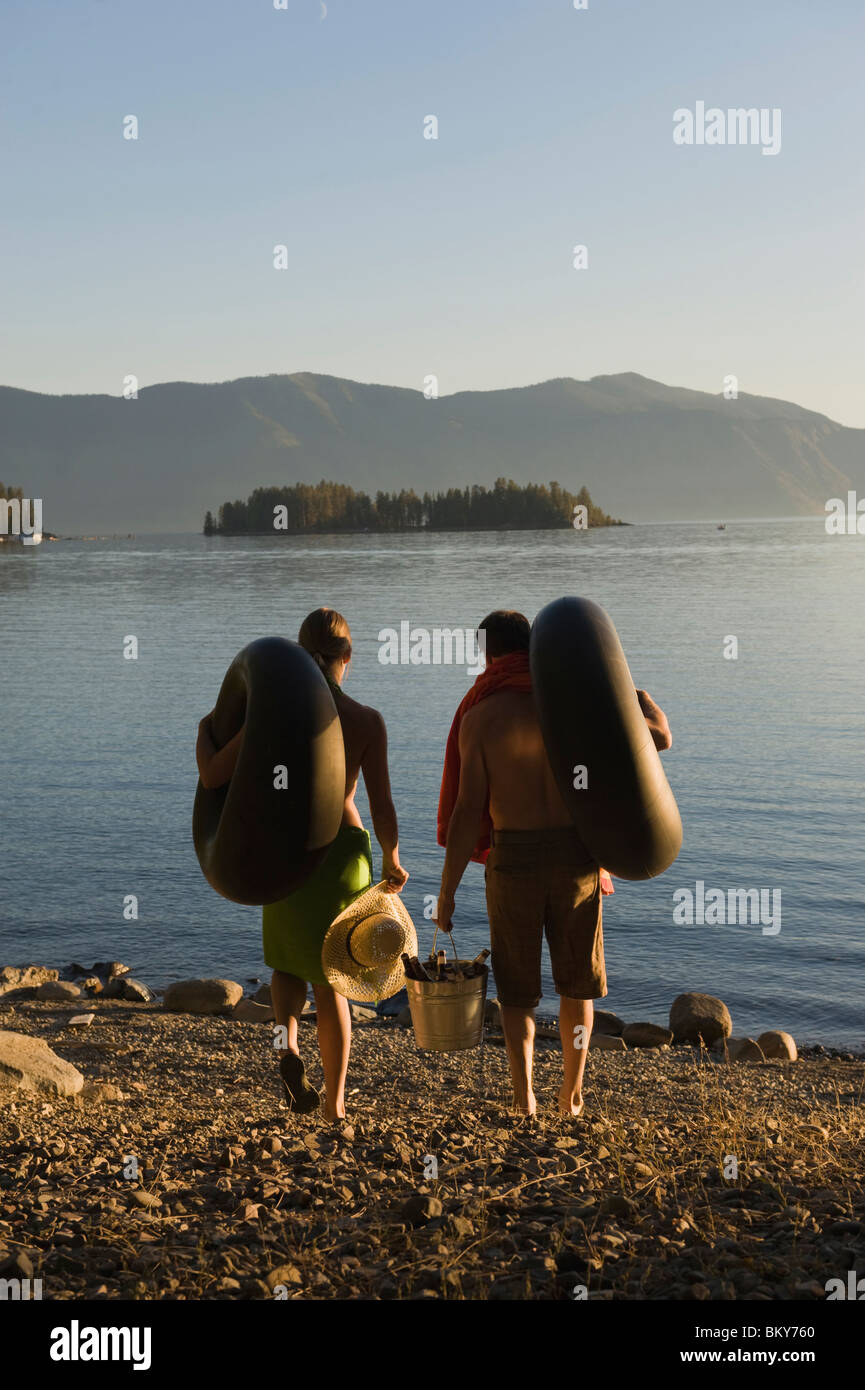 A young couple prepare to float on the lake in inner tubes during a hot ...