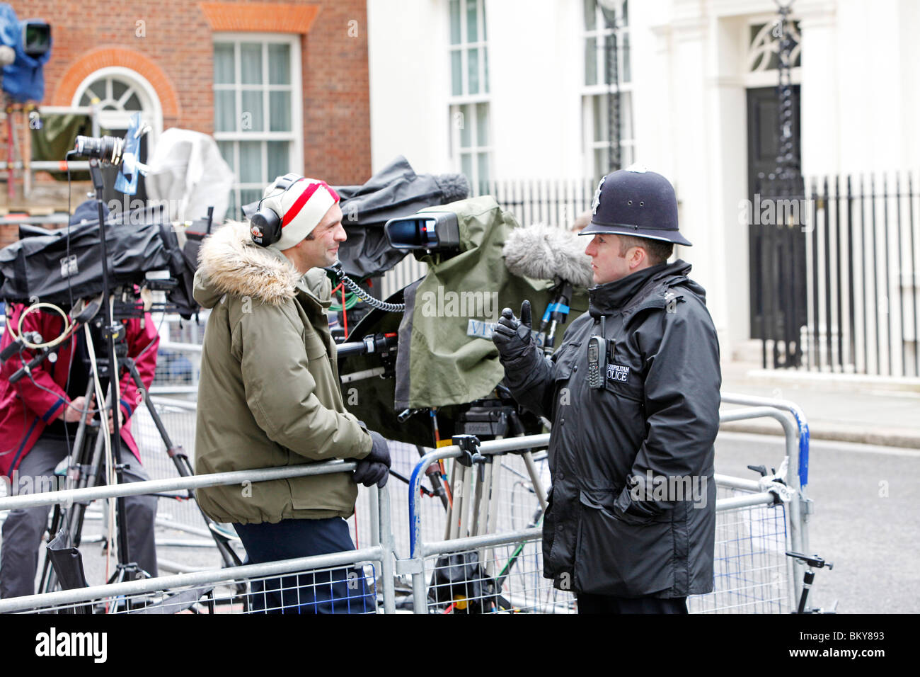 A police officer chats with a TV film crew in Downing St, London Stock ...