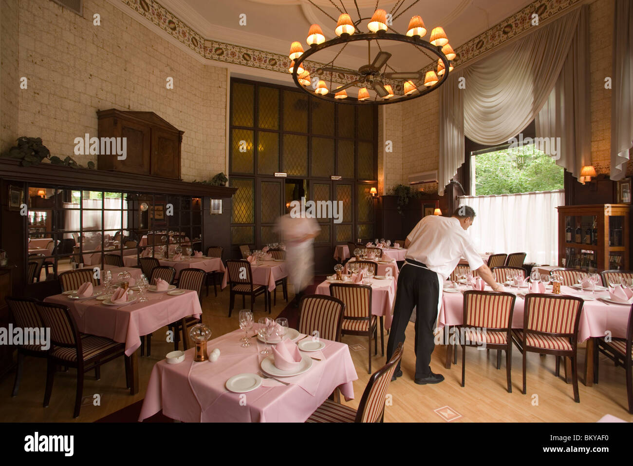 Inside the Muzeum Cafe and Restaurant, Waiter covering the tables in ...