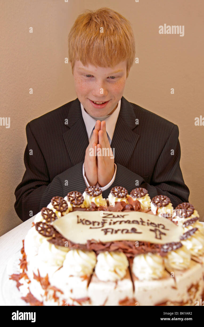 teenage boy praying in front of his confirmation cake Stock Photo - Alamy