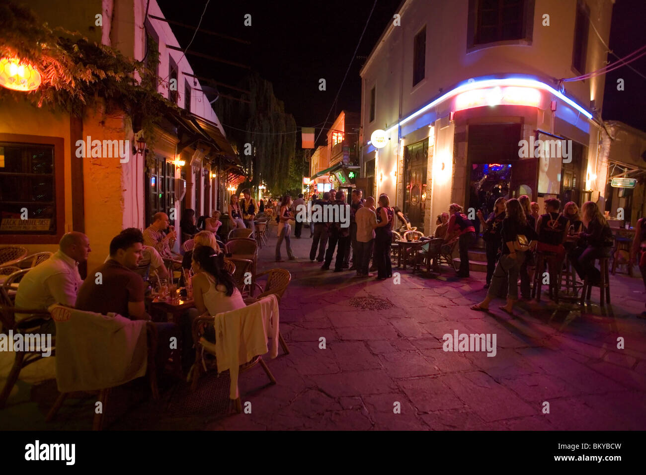 View inside a busy bar street with a lof of cafes and bars at night ...