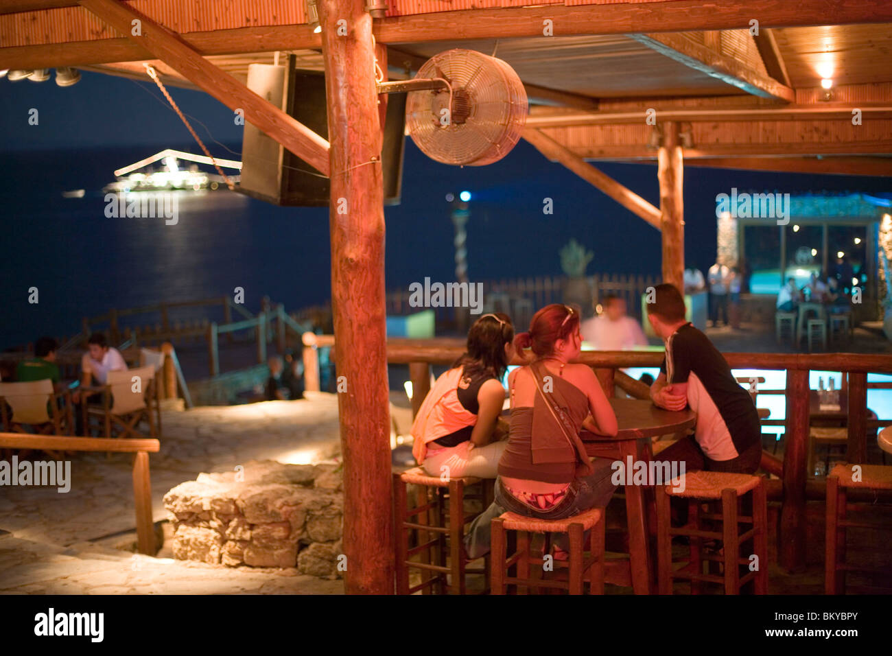 Tourists sitting in the open-air club of Cavo Paradiso, Paradise Beach ...