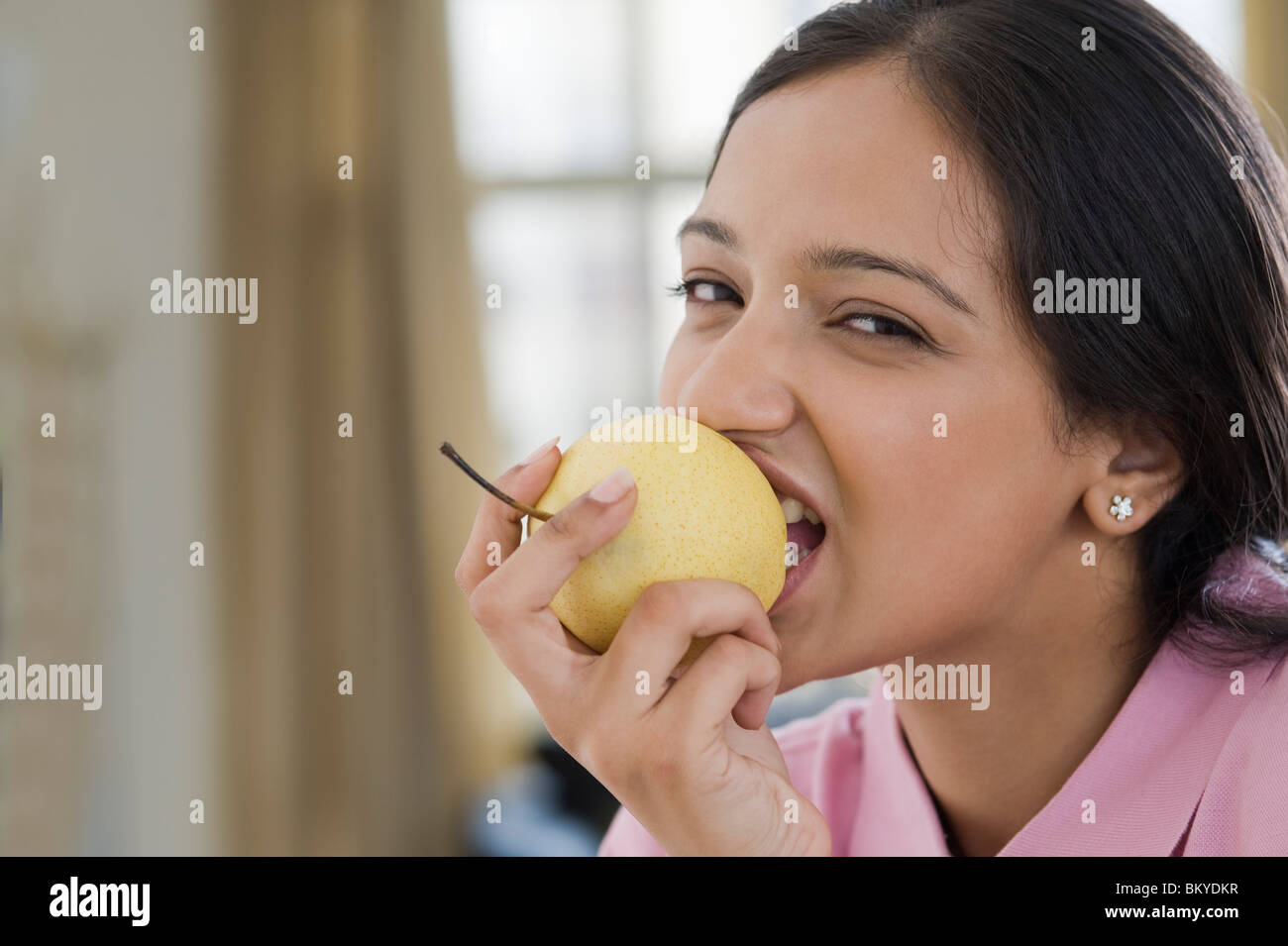 Portrait of a woman eating a pear Stock Photo - Alamy