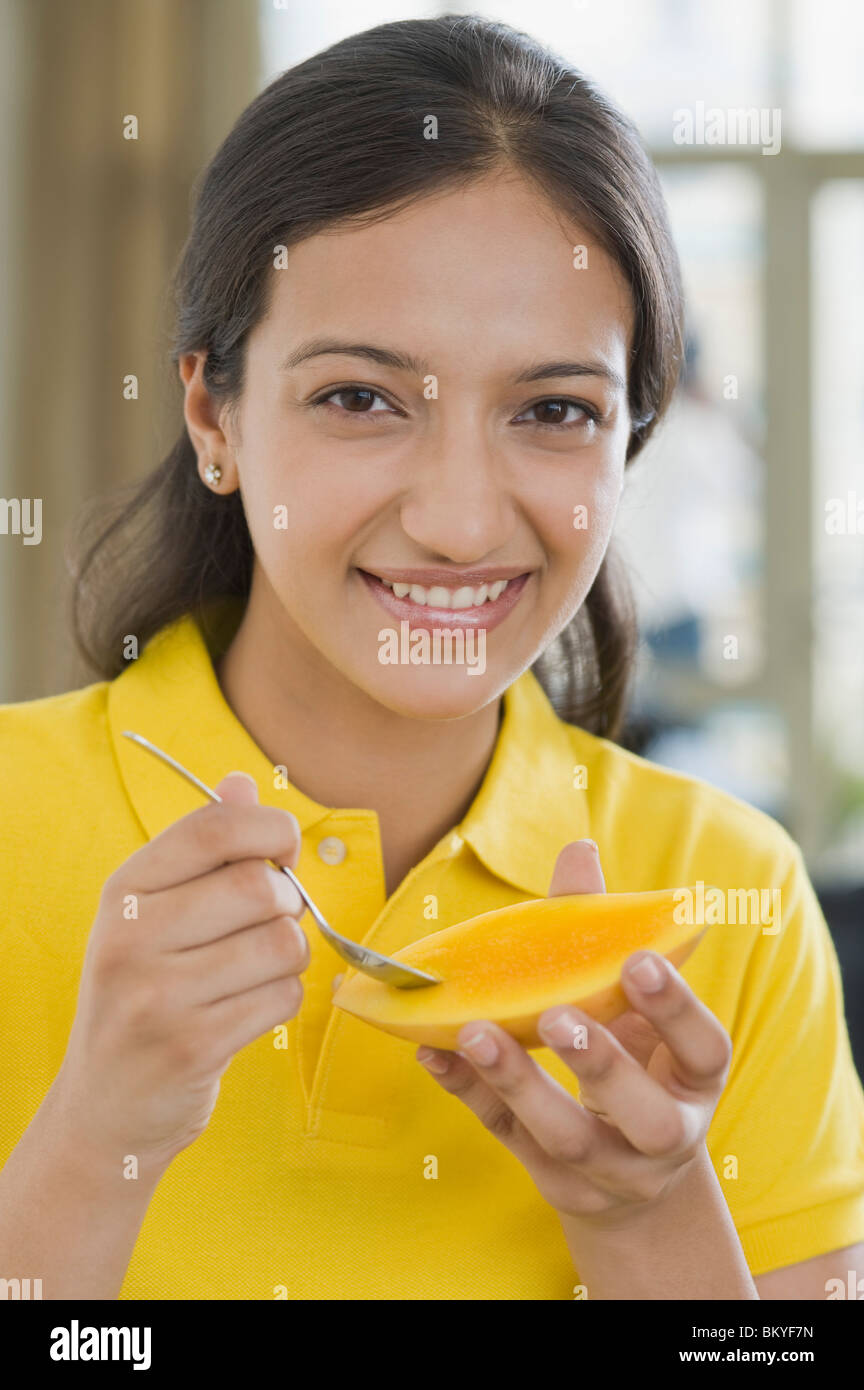 Woman eating mango with a spoon Stock Photo - Alamy