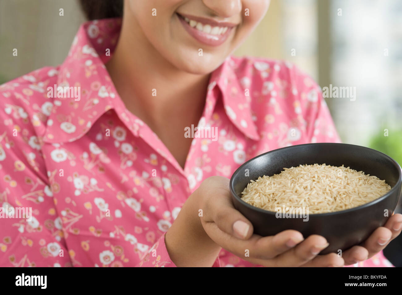 Woman holding a bowl of rice Stock Photo - Alamy