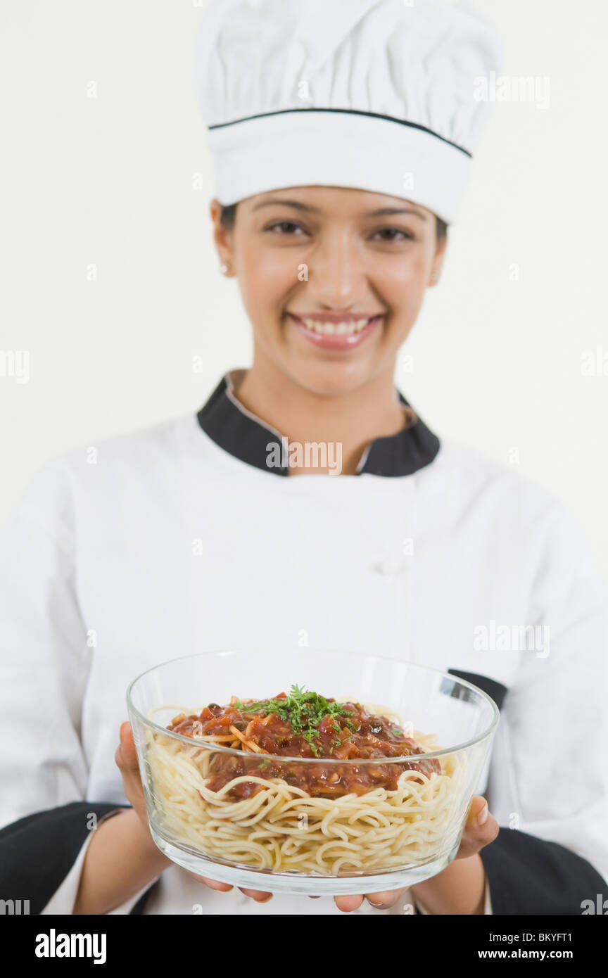 Female chef holding a bowl of spaghetti with Bolognese sauce Stock ...