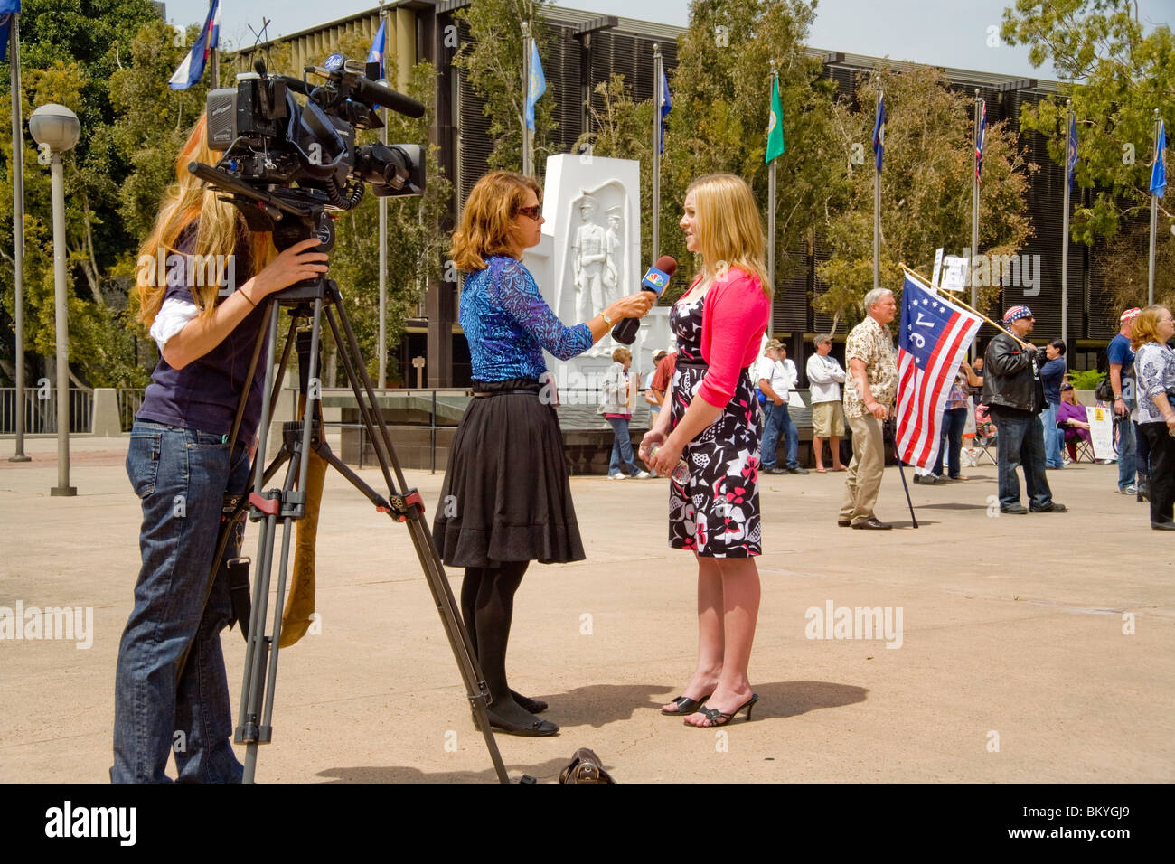 A television news reporter interviews a protester at a "Tea Party ...