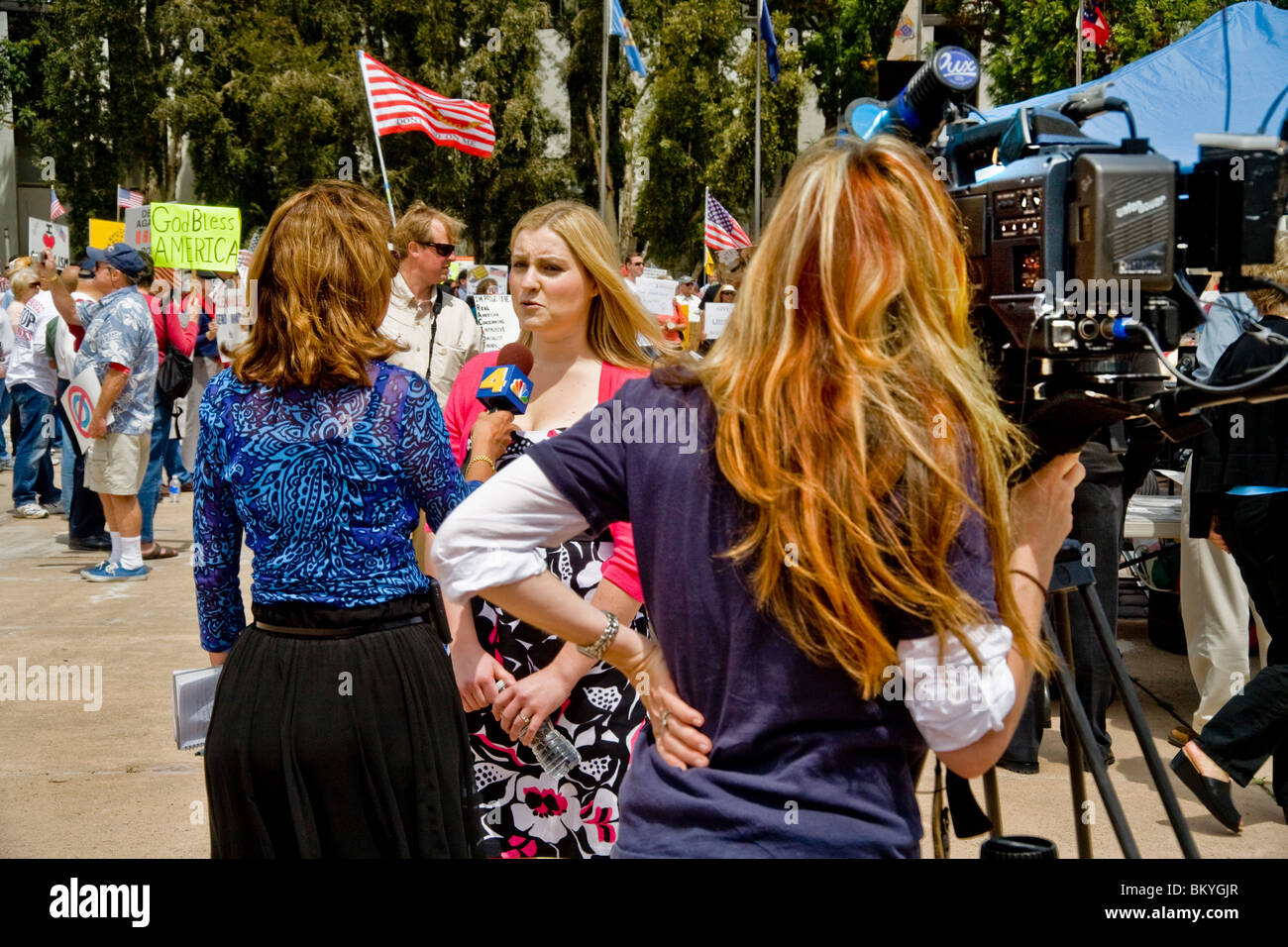 A television news reporter interviews a protester at a "Tea Party ...