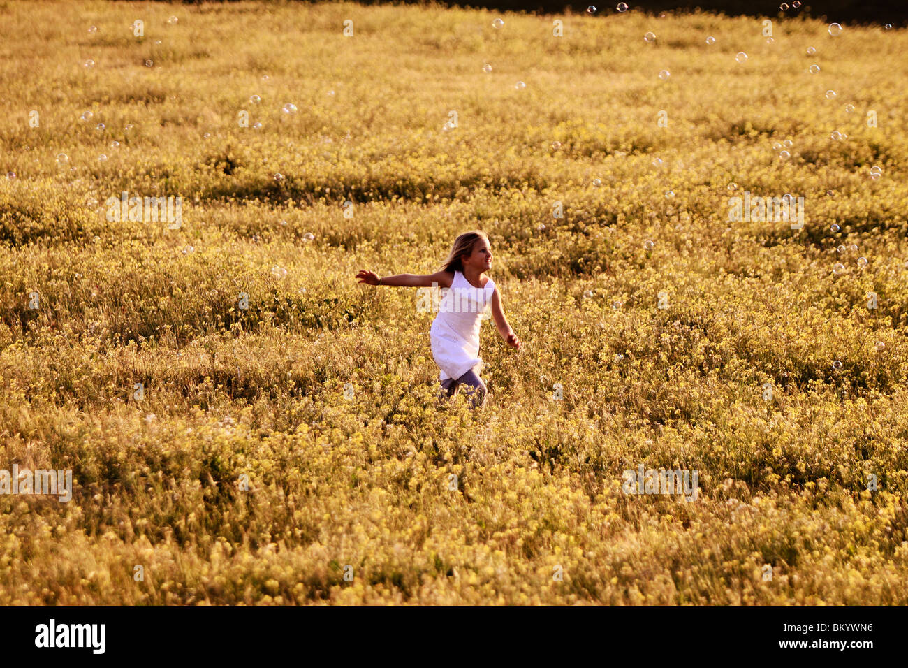 Girl walking in a field Stock Photo - Alamy