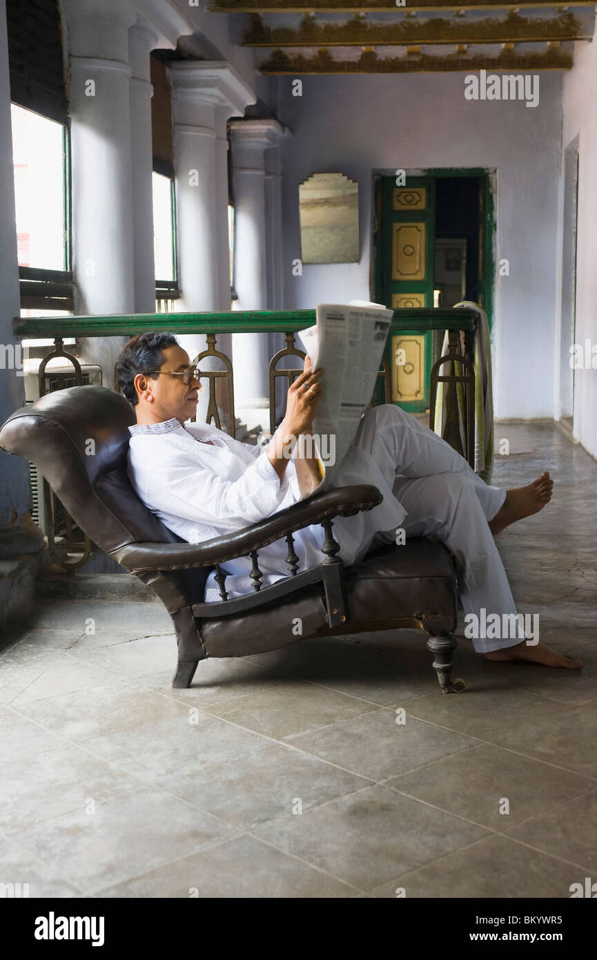 Man reading a newspaper in the balcony Stock Photo - Alamy