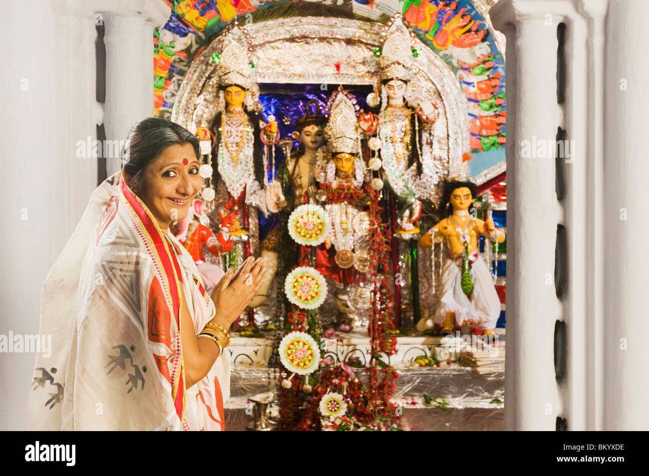 Woman praying in a temple Stock Photo - Alamy