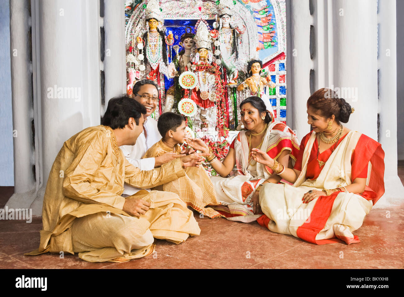 Family sitting in a temple Stock Photo - Alamy