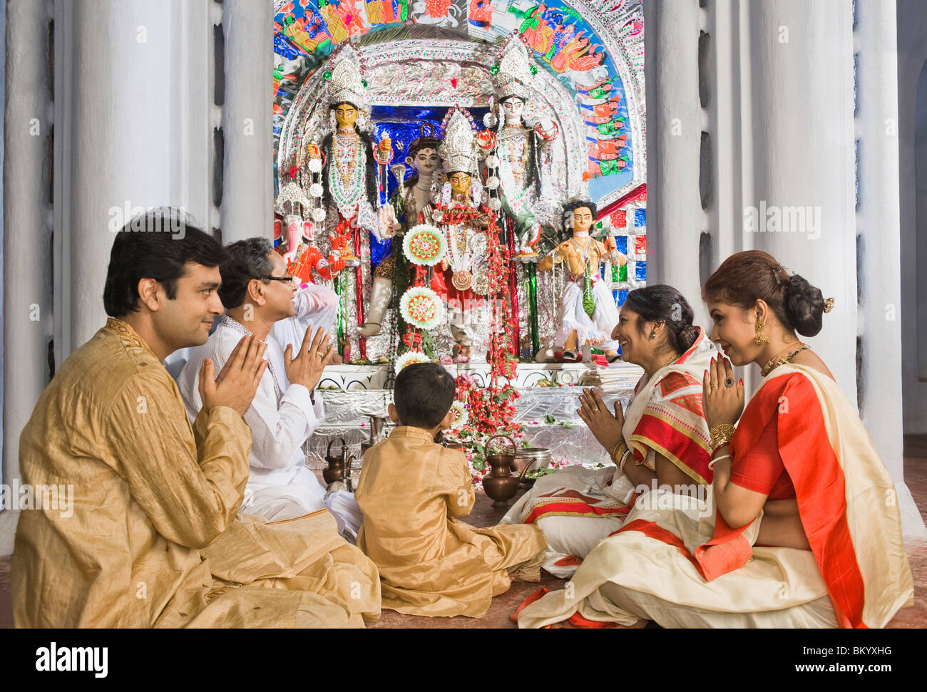 Family praying in a temple Stock Photo - Alamy