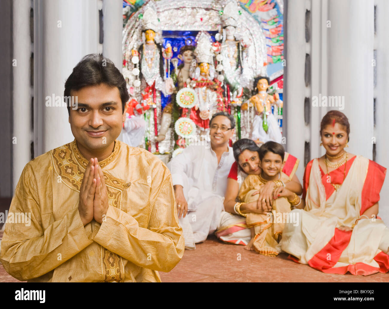 Man with his family praying in a temple Stock Photo - Alamy