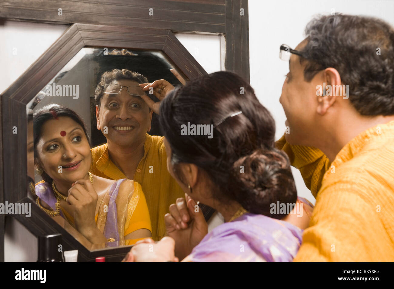 Couple smiling in front of a mirror Stock Photo - Alamy