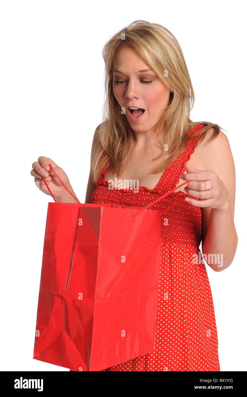Beautiful young woman opening gift bag and expressing surprise Stock ...