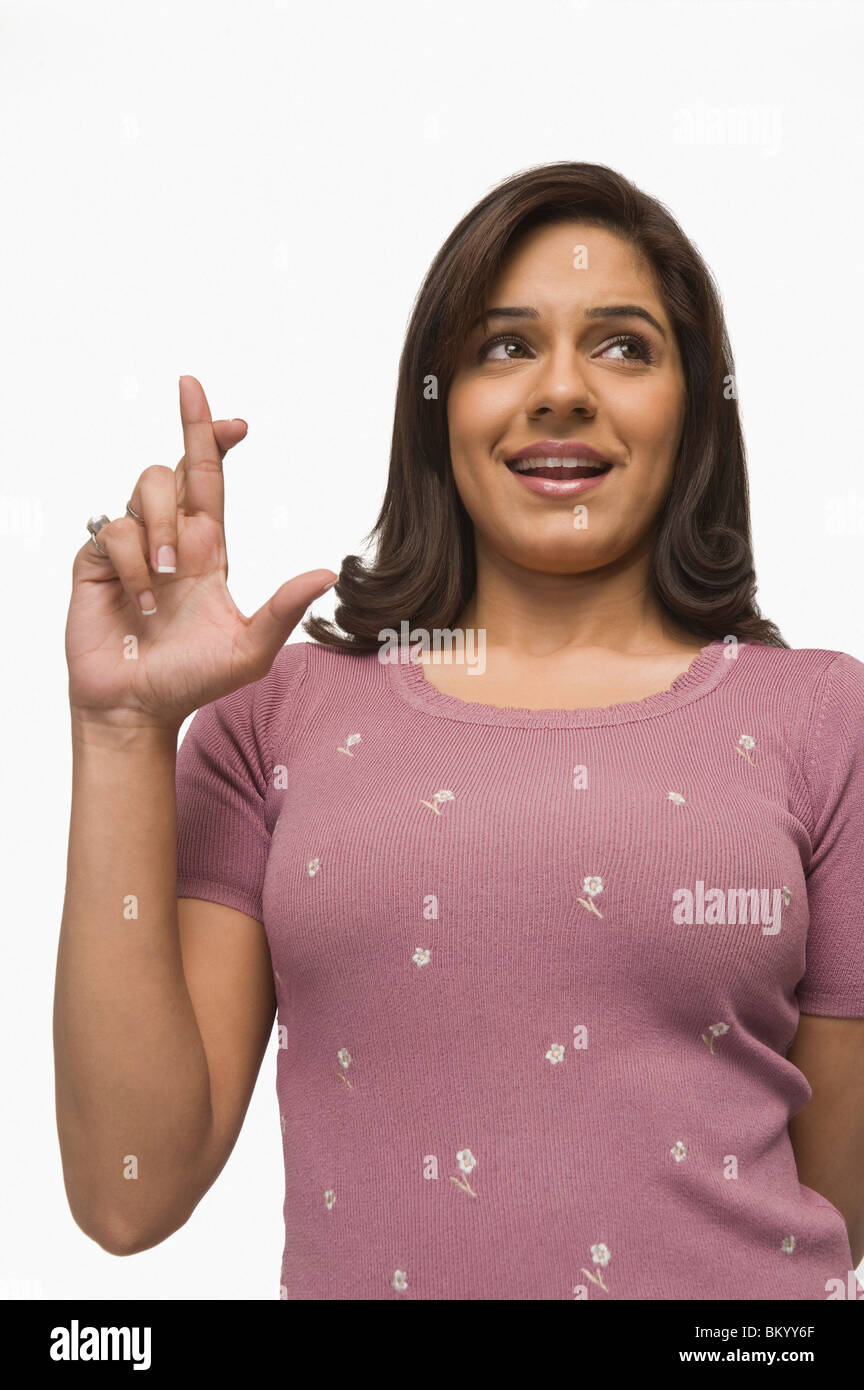 Woman standing with her fingers crossed Stock Photo - Alamy