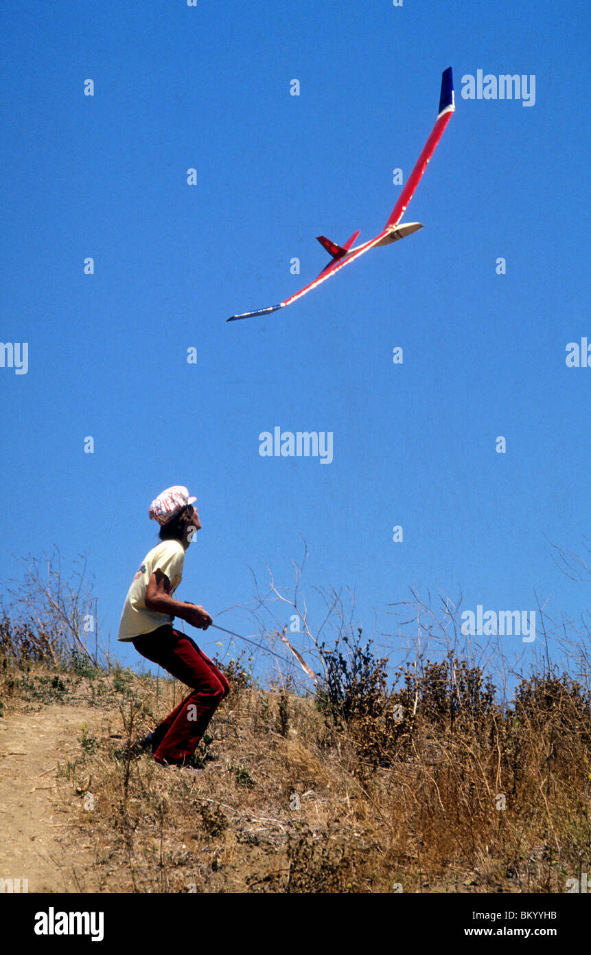 High school male boy fly flies radio-controlled model sailplane against ...