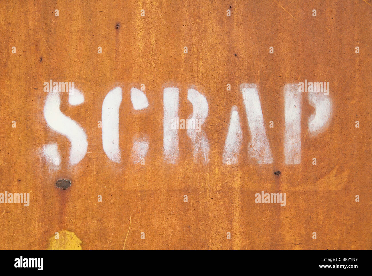 grungy word scrap painted on side of rustic yellow and orange metal ...