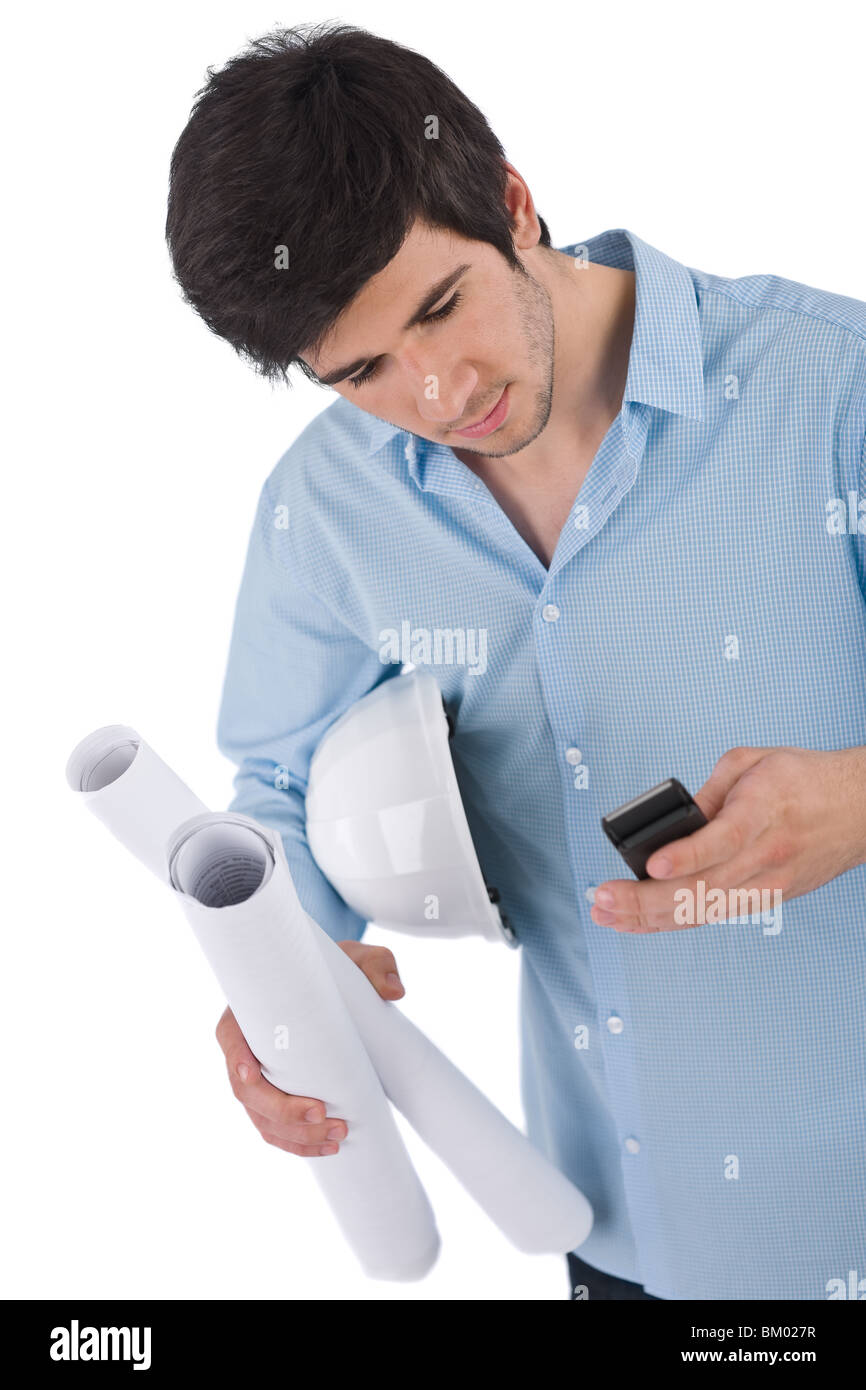 Male architect student with helmet and plans sending text message with ...