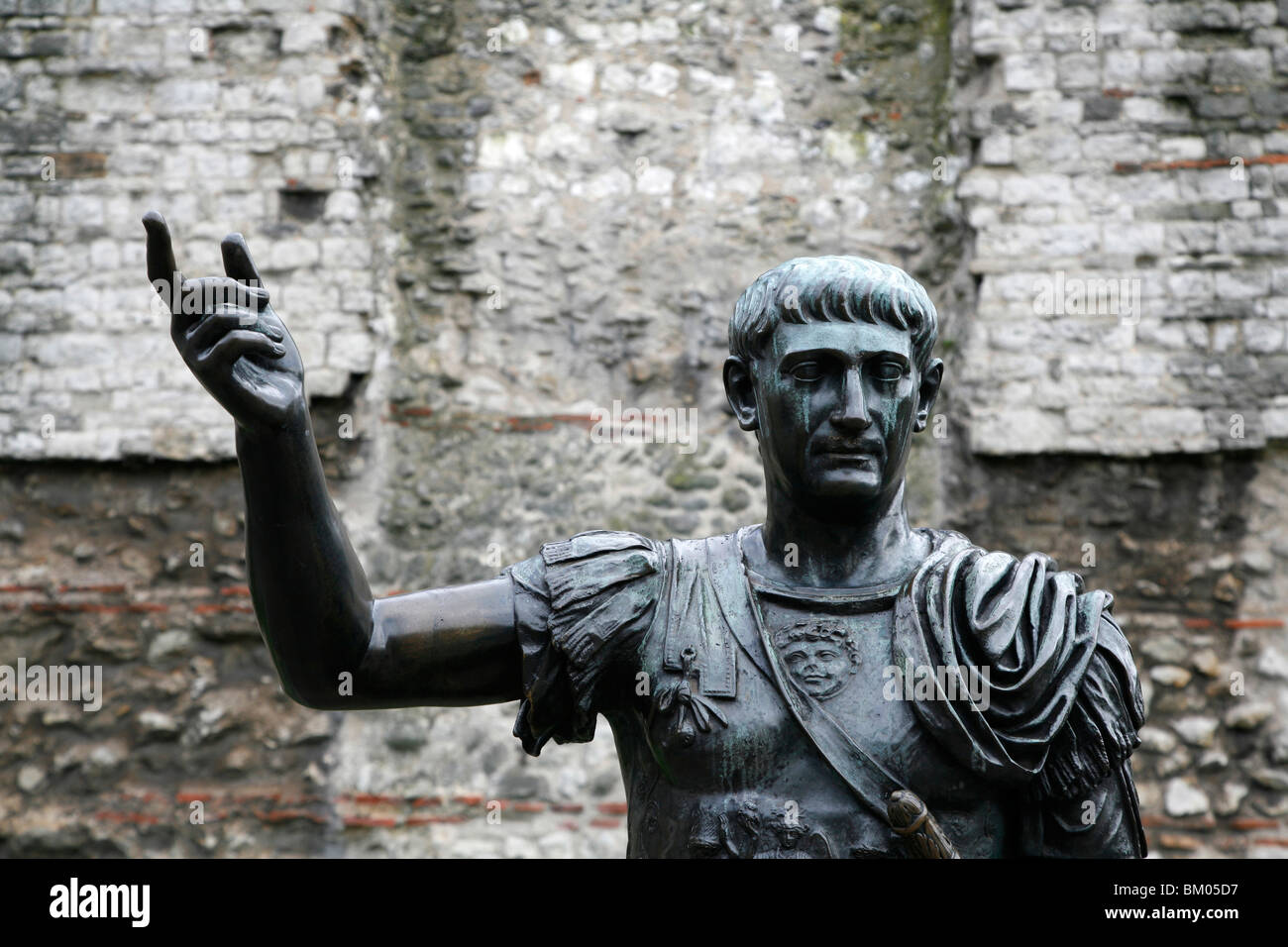 Statue of Emperor Trajan in front of remains of the old London Wall at ...