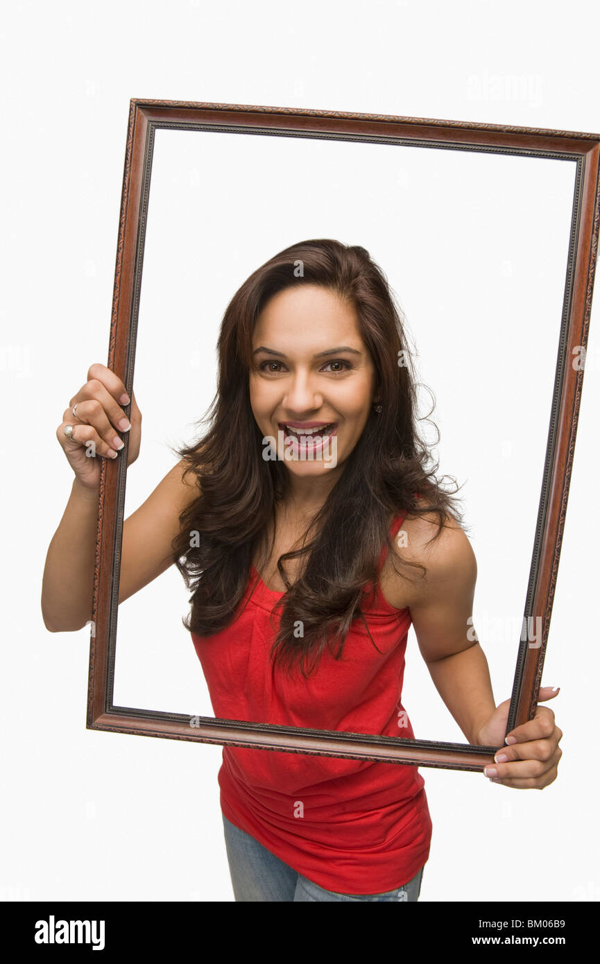 Woman holding a frame and smiling Stock Photo - Alamy