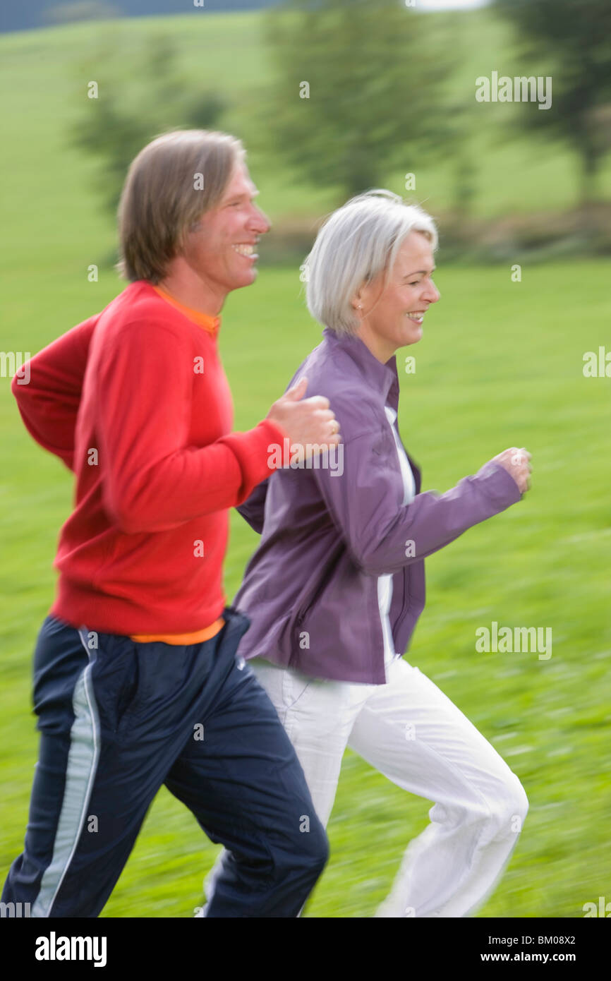 Couple running in field Stock Photo - Alamy