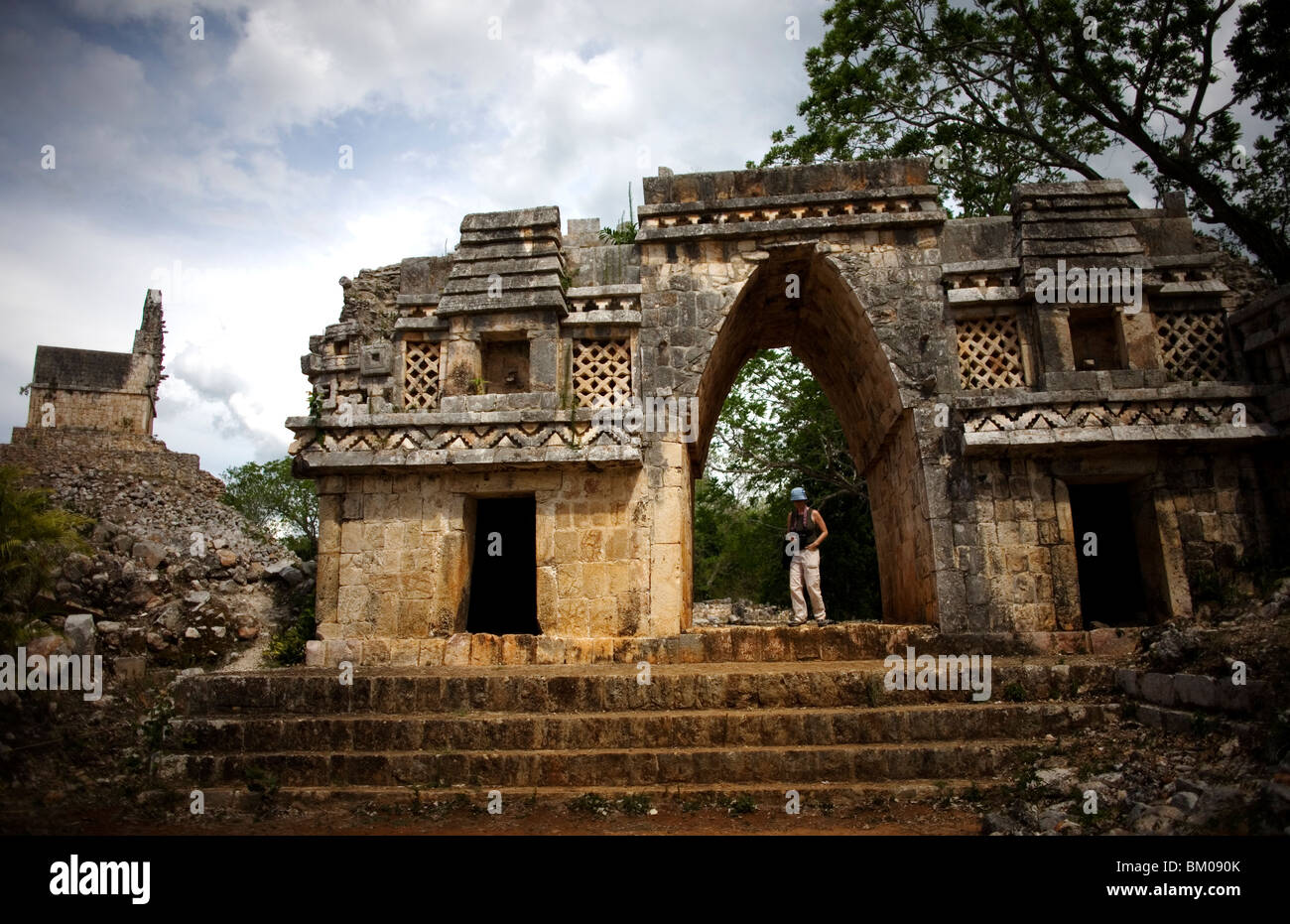 A tourist walks by a Mayan arch among the ruins of Labna, along the ...