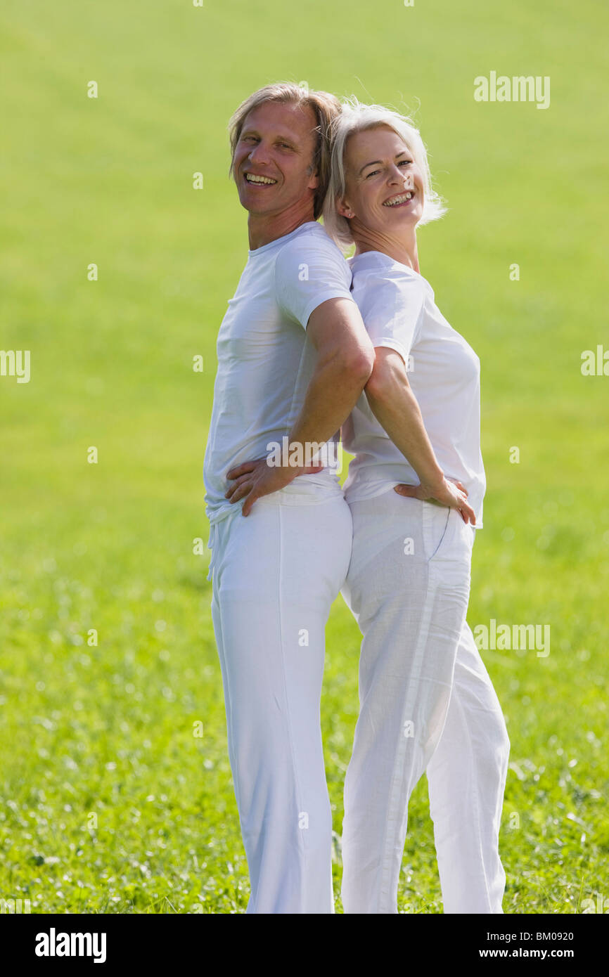 Couple standing back to back Stock Photo - Alamy