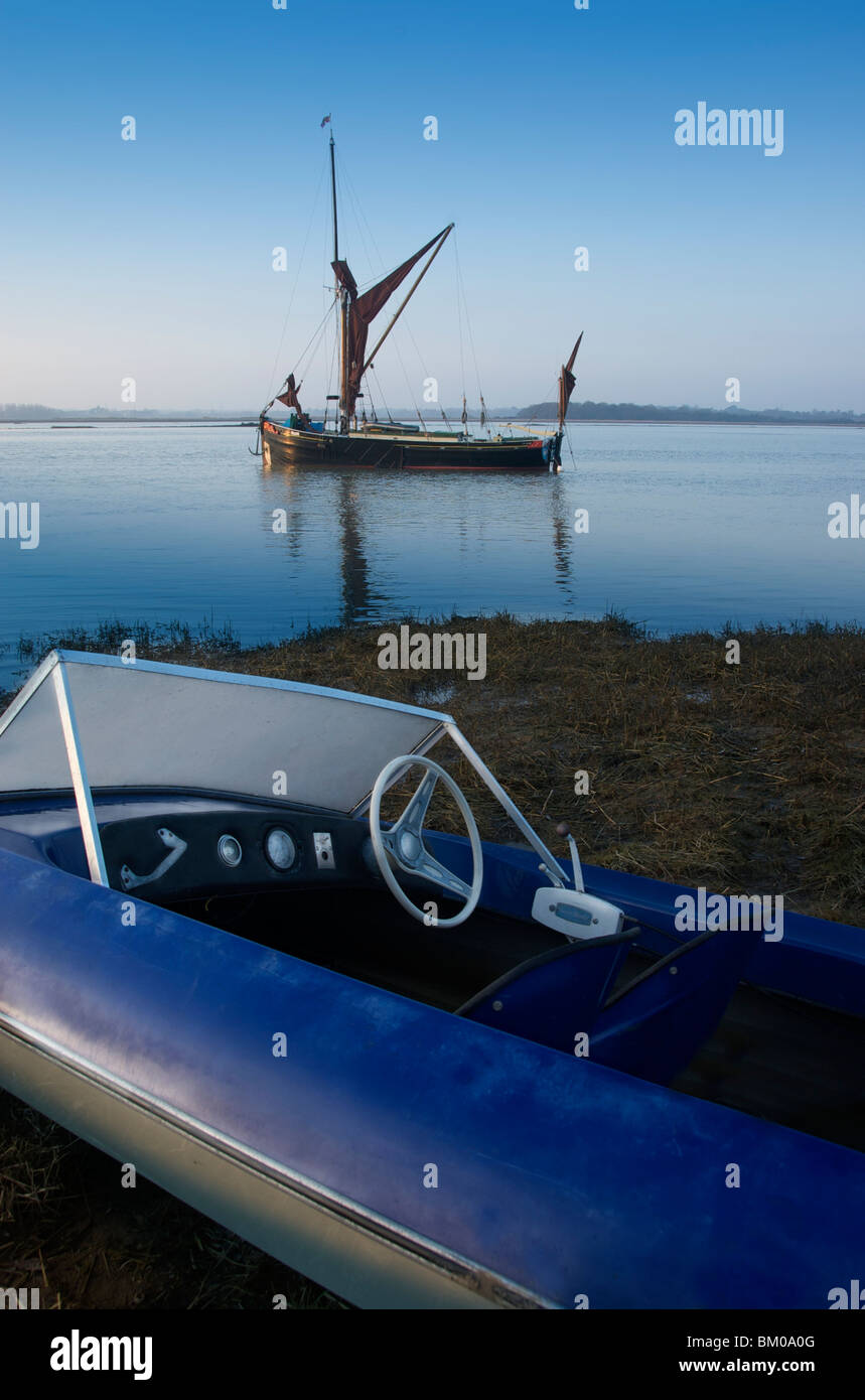 Speed boat on shore with old sail boat on river, Eiken Suffolk England ...