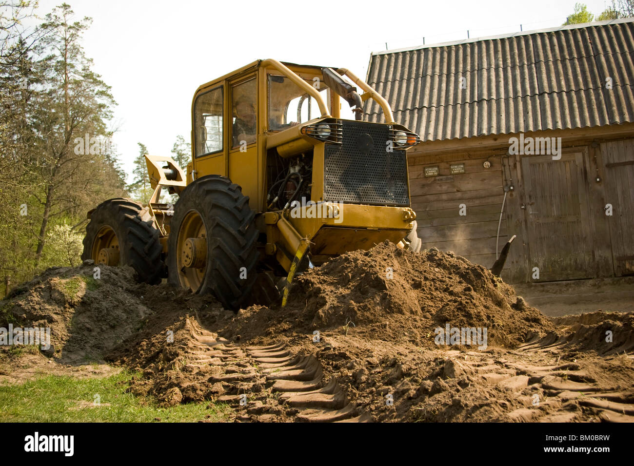 Yellow bulldozer in forest Stock Photo - Alamy