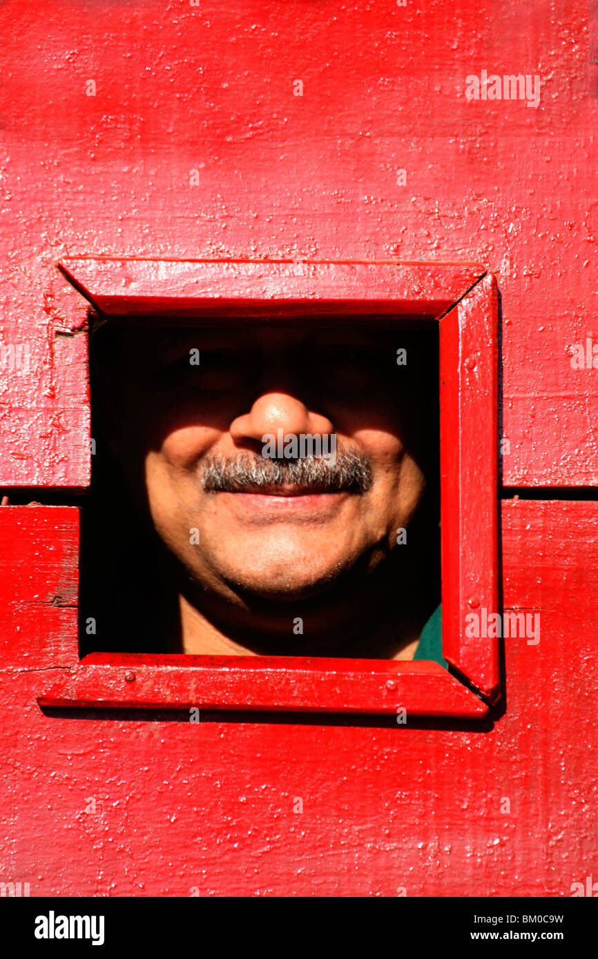 A person looking through a small window Stock Photo - Alamy
