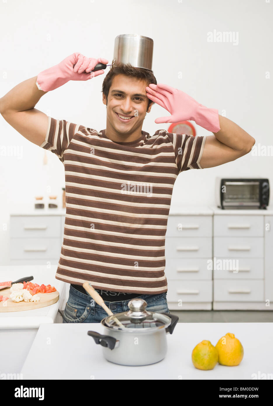 Man holding a cooking pan on his head and smiling Stock Photo - Alamy