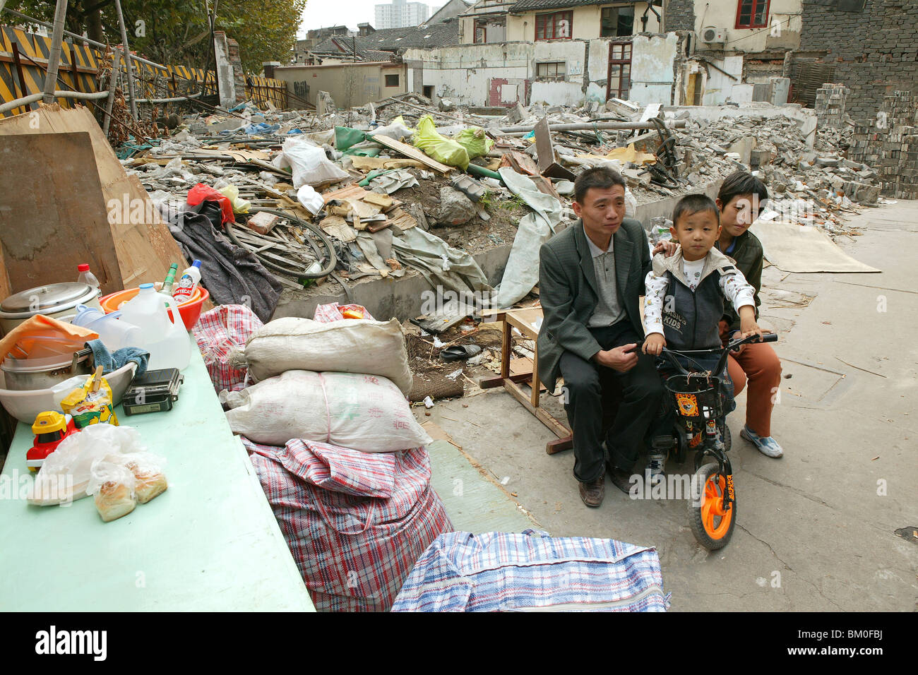 demolition, couple with child between the ruins of their former house ...