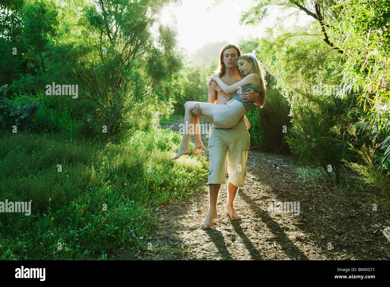 Young man carrying young woman Stock Photo - Alamy