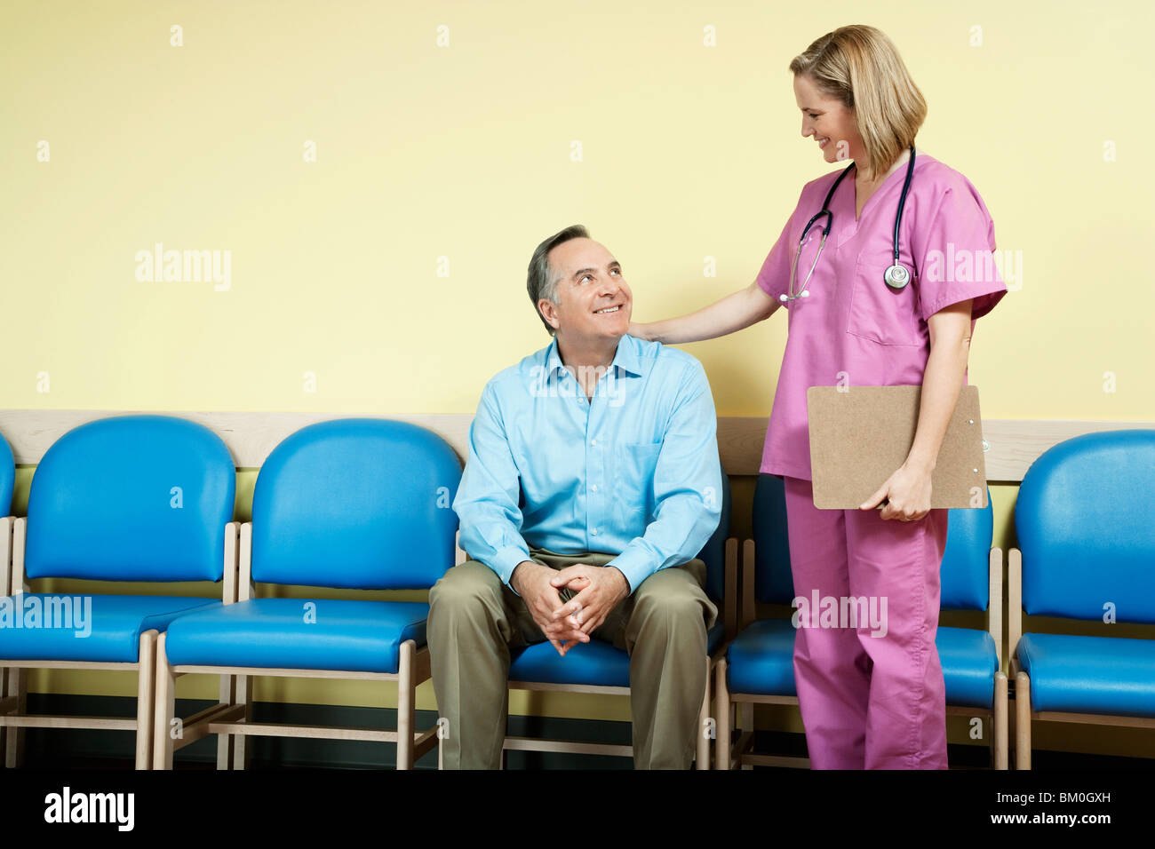 Female nurse talking to a patient in the waiting room Stock Photo - Alamy