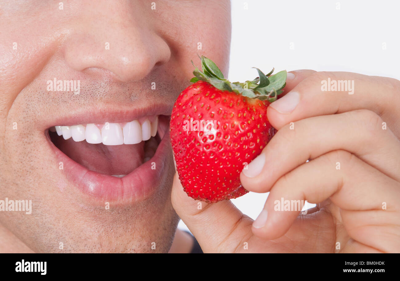 Man eating a strawberry Stock Photo - Alamy