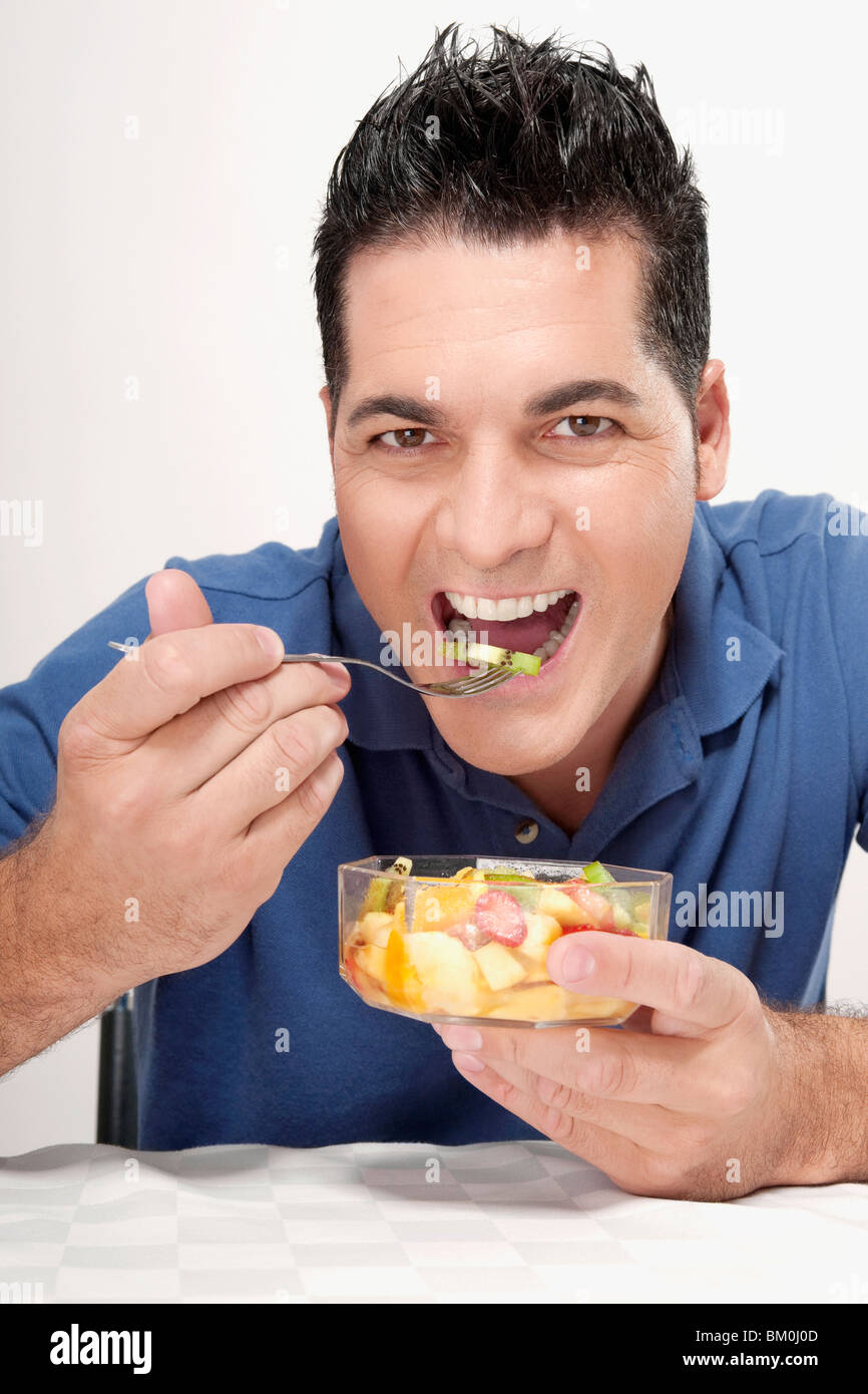 Portrait of a man eating fruit salad Stock Photo - Alamy