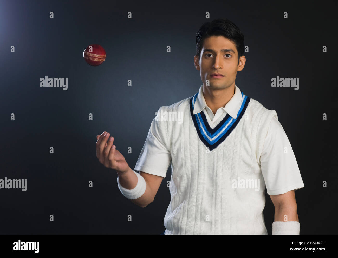 Portrait of a cricket player tossing a cricket ball Stock Photo - Alamy